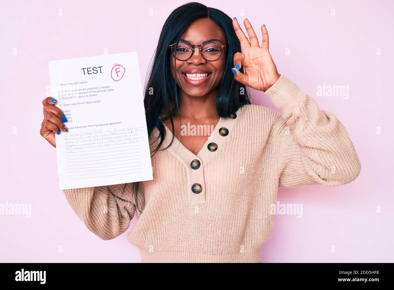 Young african american woman showing a failed exam doing ok sign with ...