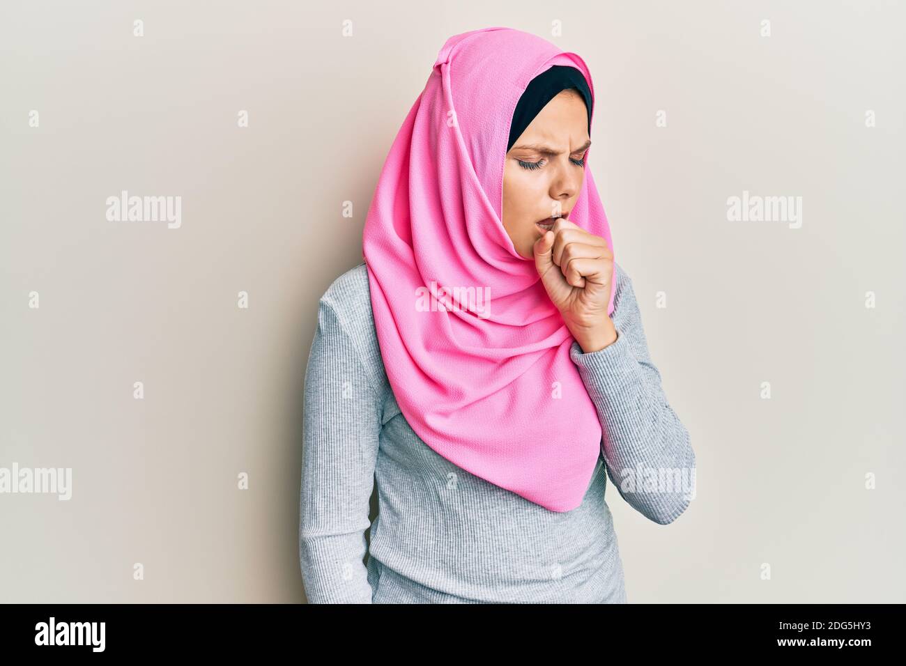 Young caucasian woman wearing traditional islamic hijab scarf feeling ...
