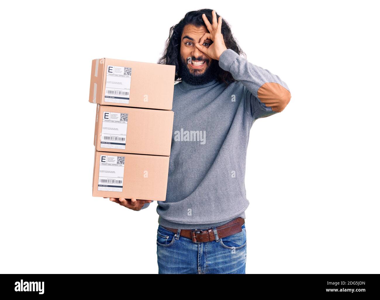 Young arab man holding delivery package smiling happy doing ok sign ...