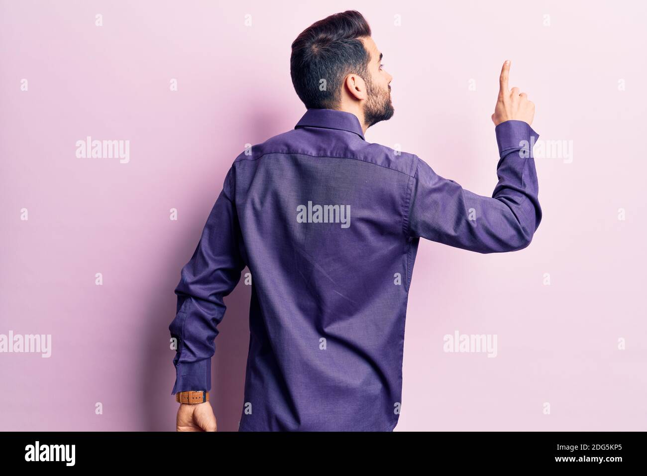 Young handsome man with beard wearing casual shirt posing backwards ...