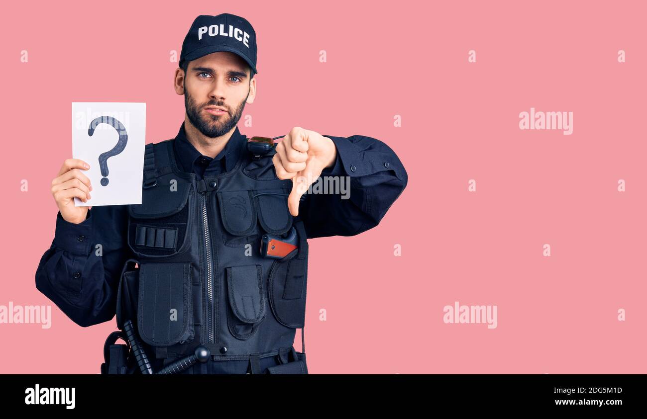 Young handsome man with beard wearing police uniform holding question ...