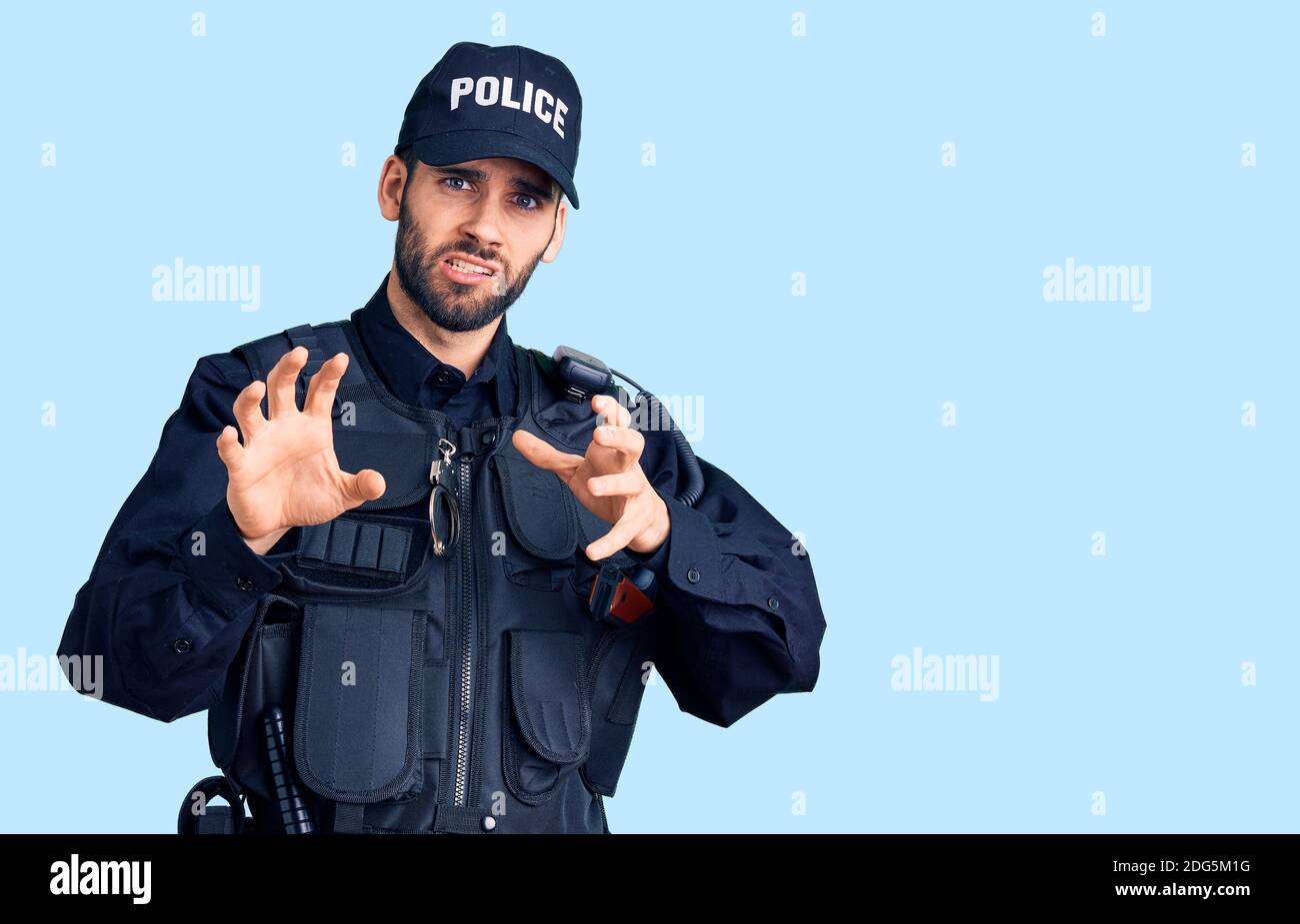 Young handsome man with beard wearing police uniform disgusted ...