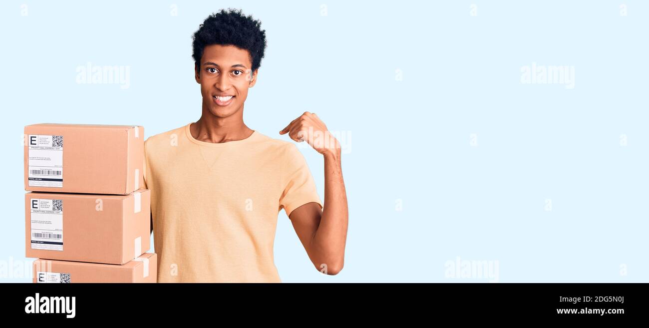 Young african american man holding delivery package pointing finger to ...