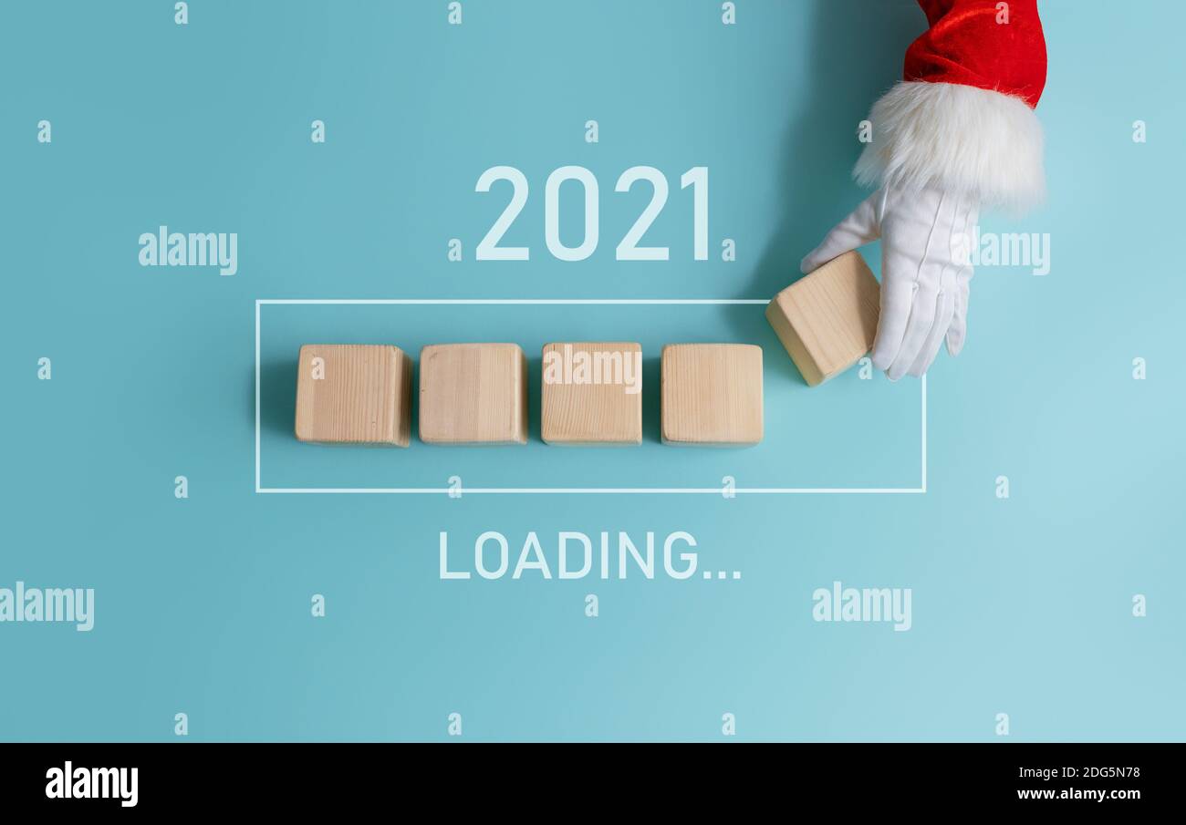 Loading new year 2020 to 2021 with hand of Santa Claus putting wood ...