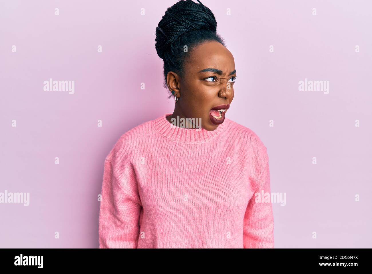 Young african american woman wearing casual winter sweater angry and ...