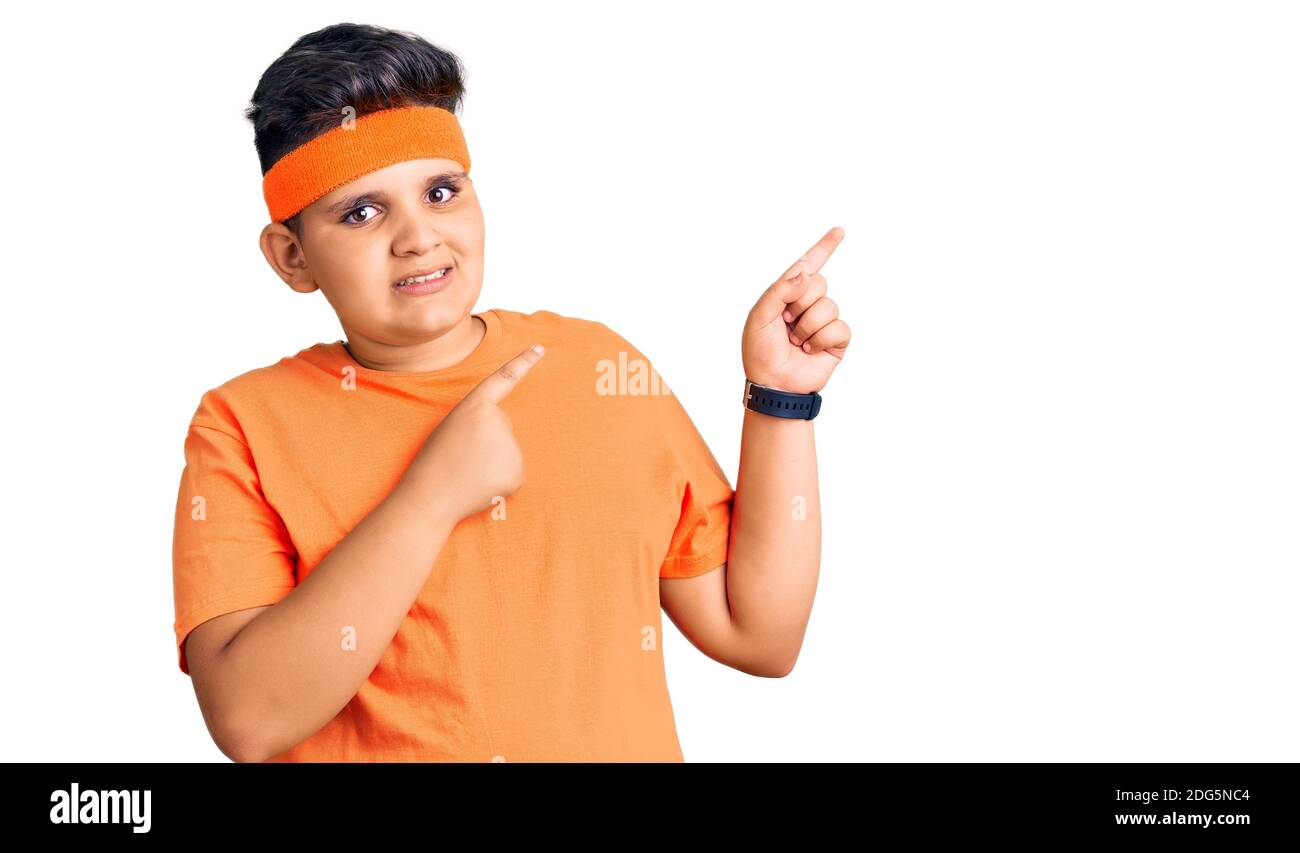 Little boy kid wearing sportswear pointing aside worried and nervous ...