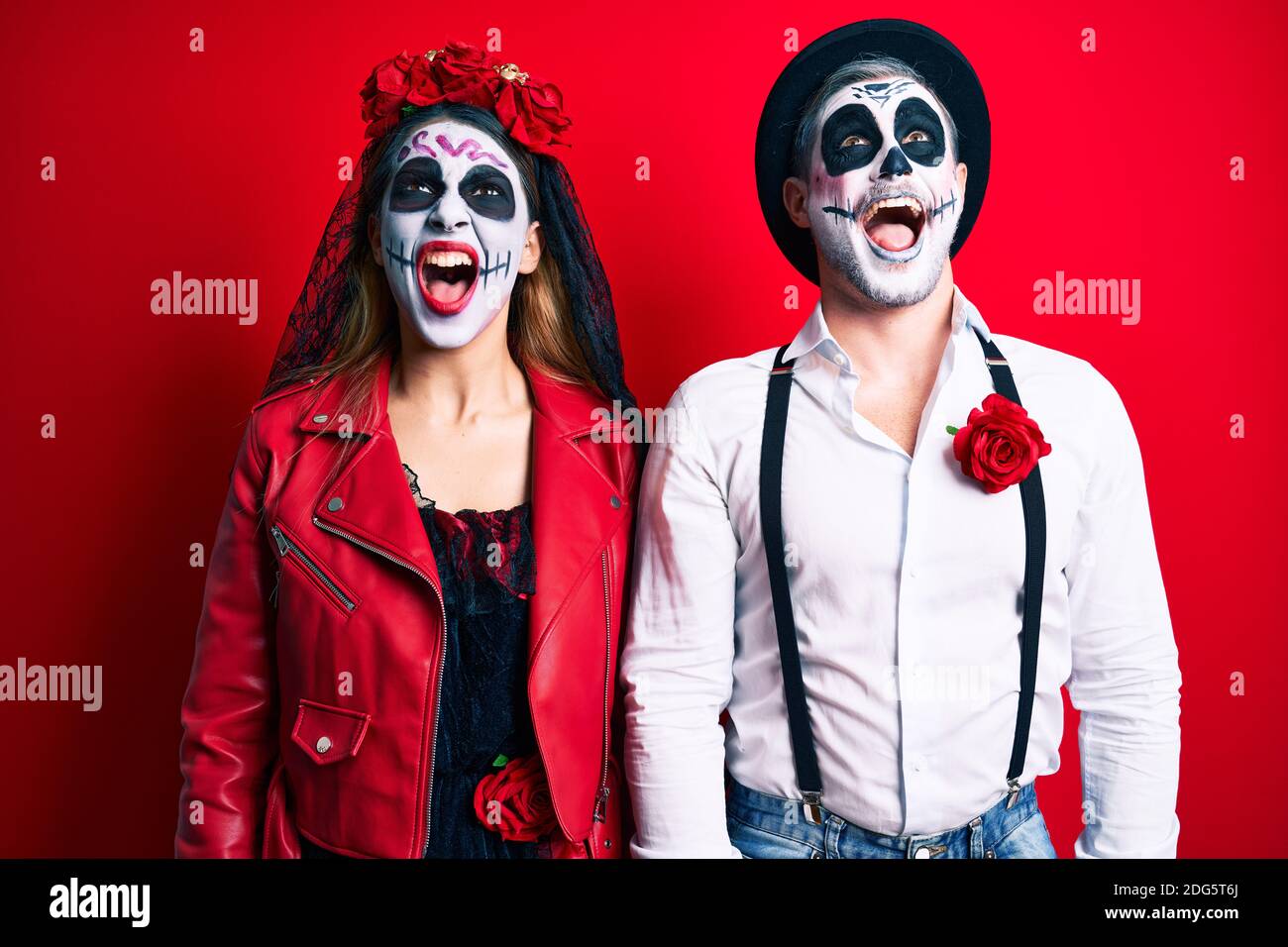 Couple wearing day of the dead costume over red angry and mad screaming ...