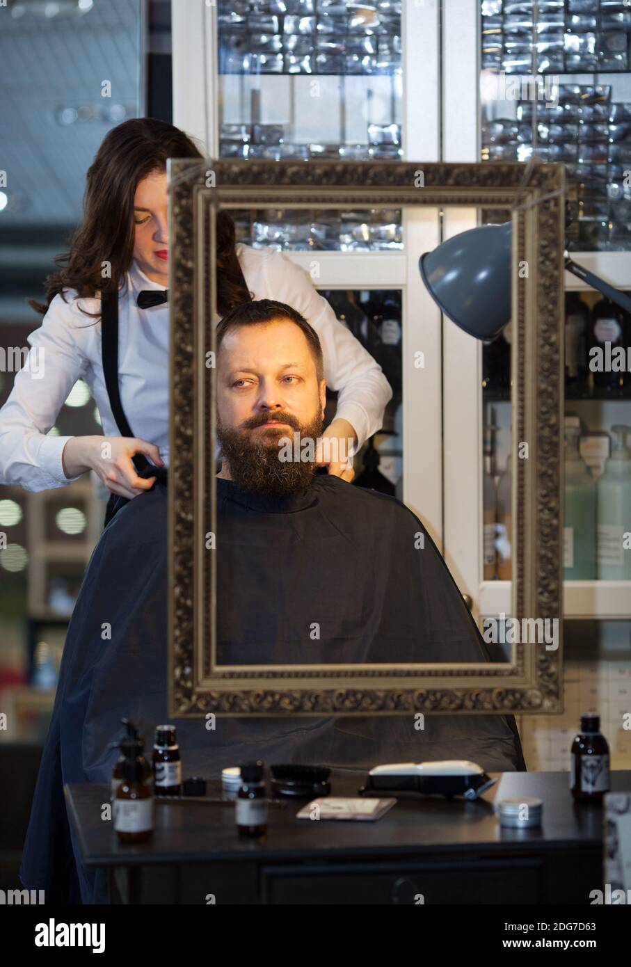Man having his beard and hair trimmed at a barber Stock Photo - Alamy