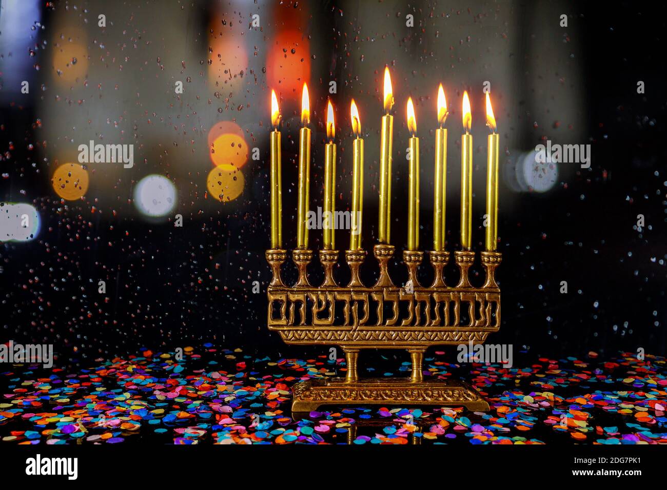 Burning menorah with pink candles and confetti on black background ...