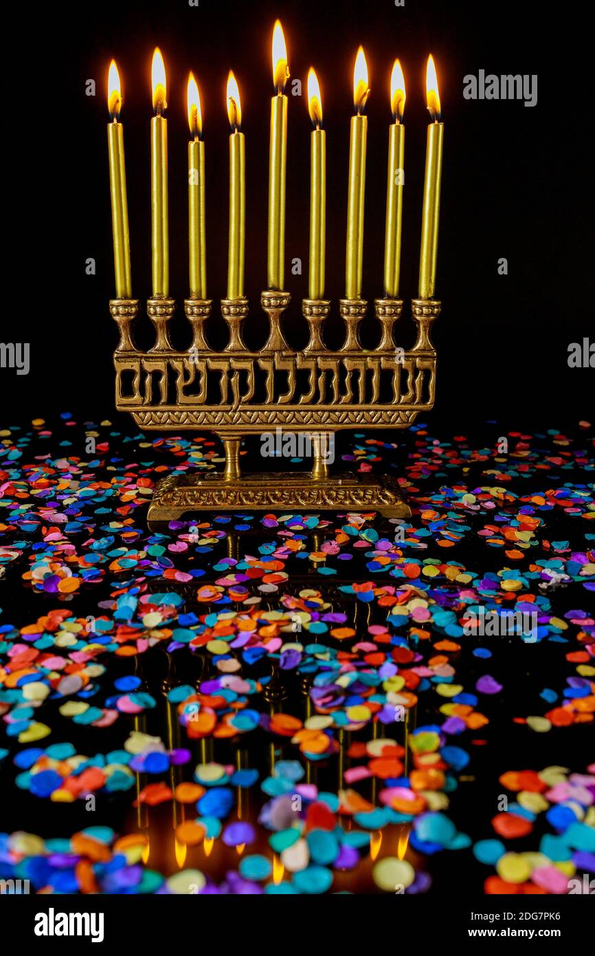 Golden candles on menorah and confetti on black background. Jewish ...