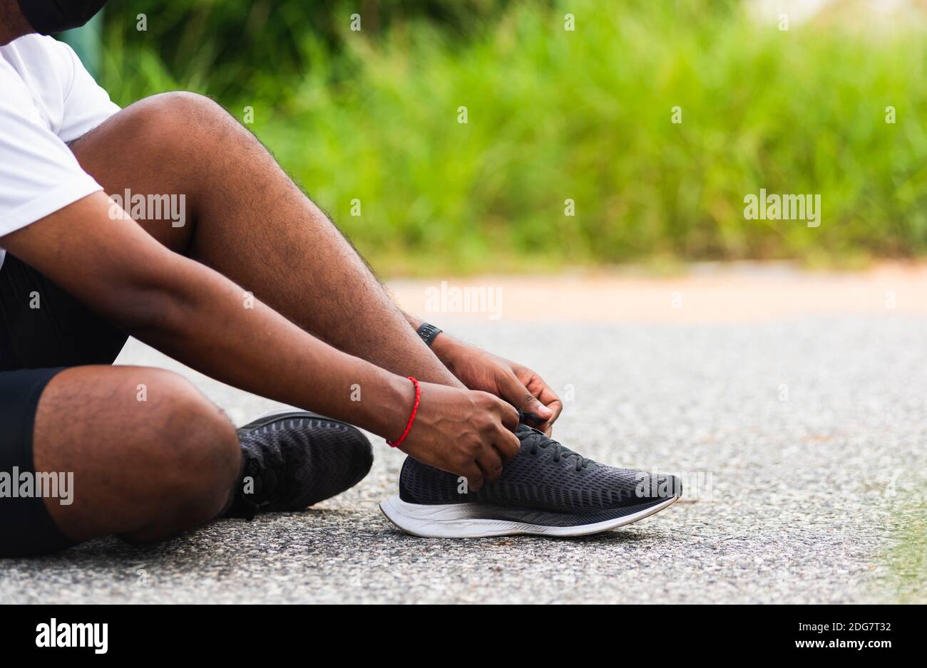 Close up Asian sport runner black man sitting shoelace trying running ...