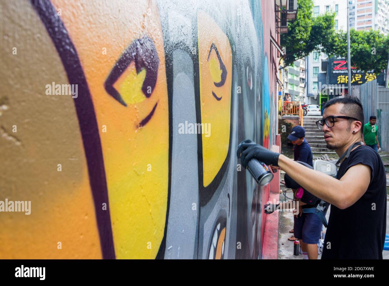 Malaysian street artist Kenji Chai doing a wall mural in Kuala Lumpur ...