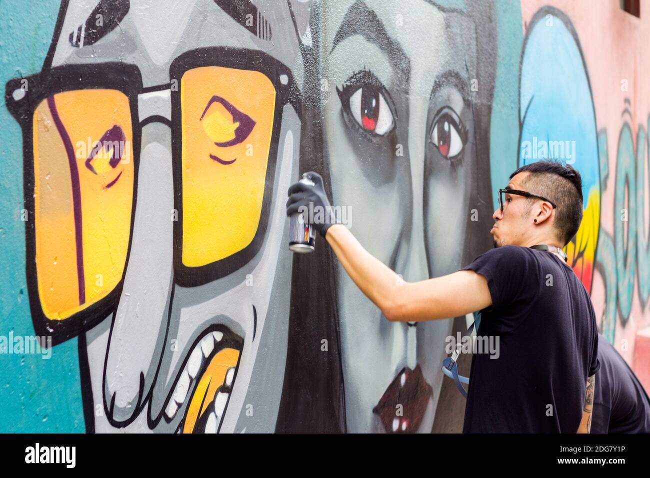 Malaysian street artist Kenji Chai doing a wall mural in Kuala Lumpur ...