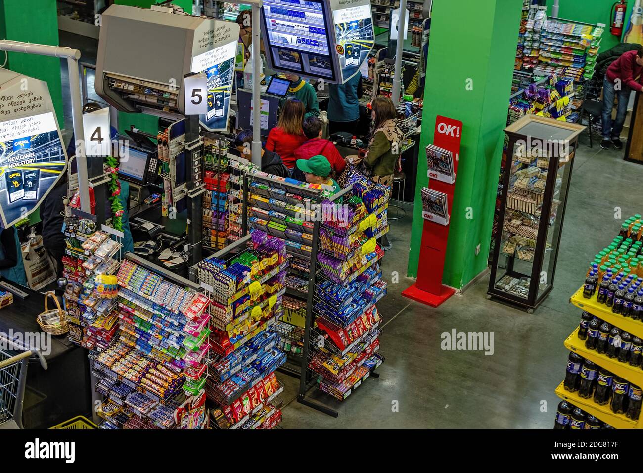 Supermarket checkout counters lines with goods and people. View from ...
