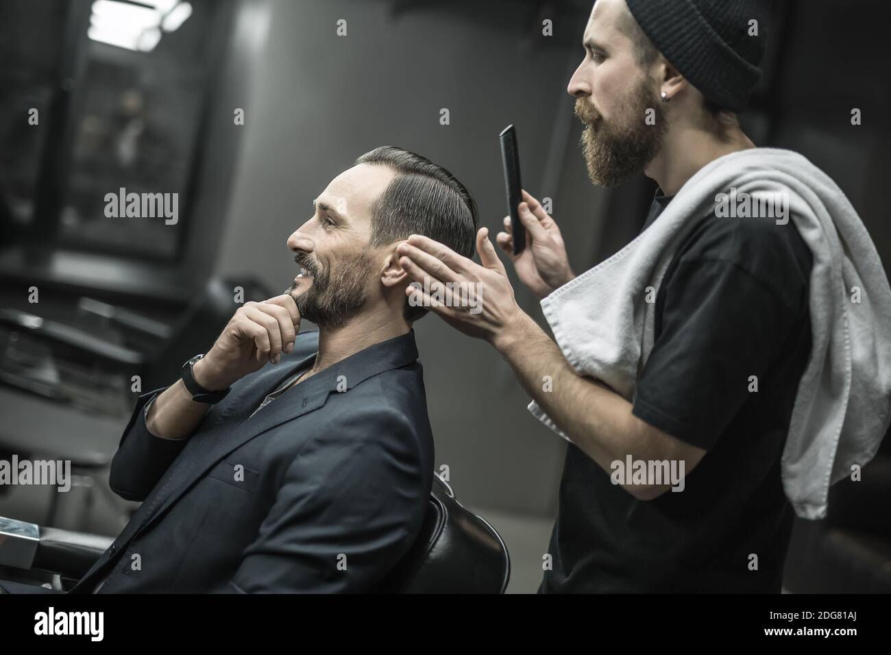 Making hairstyle in barbershop Stock Photo - Alamy
