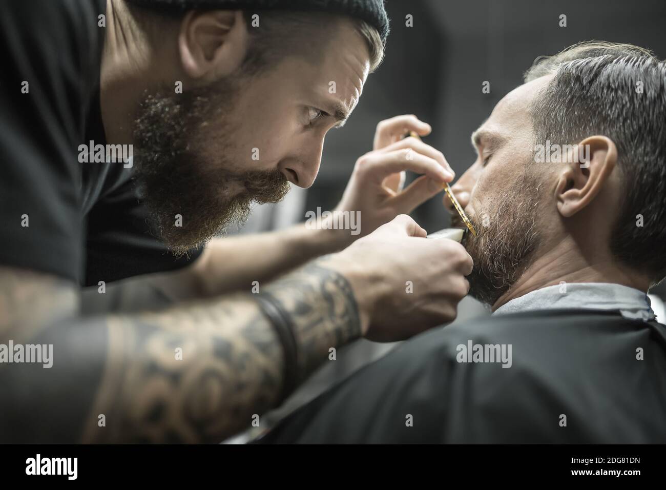 Trimming beard in barbershop Stock Photo - Alamy