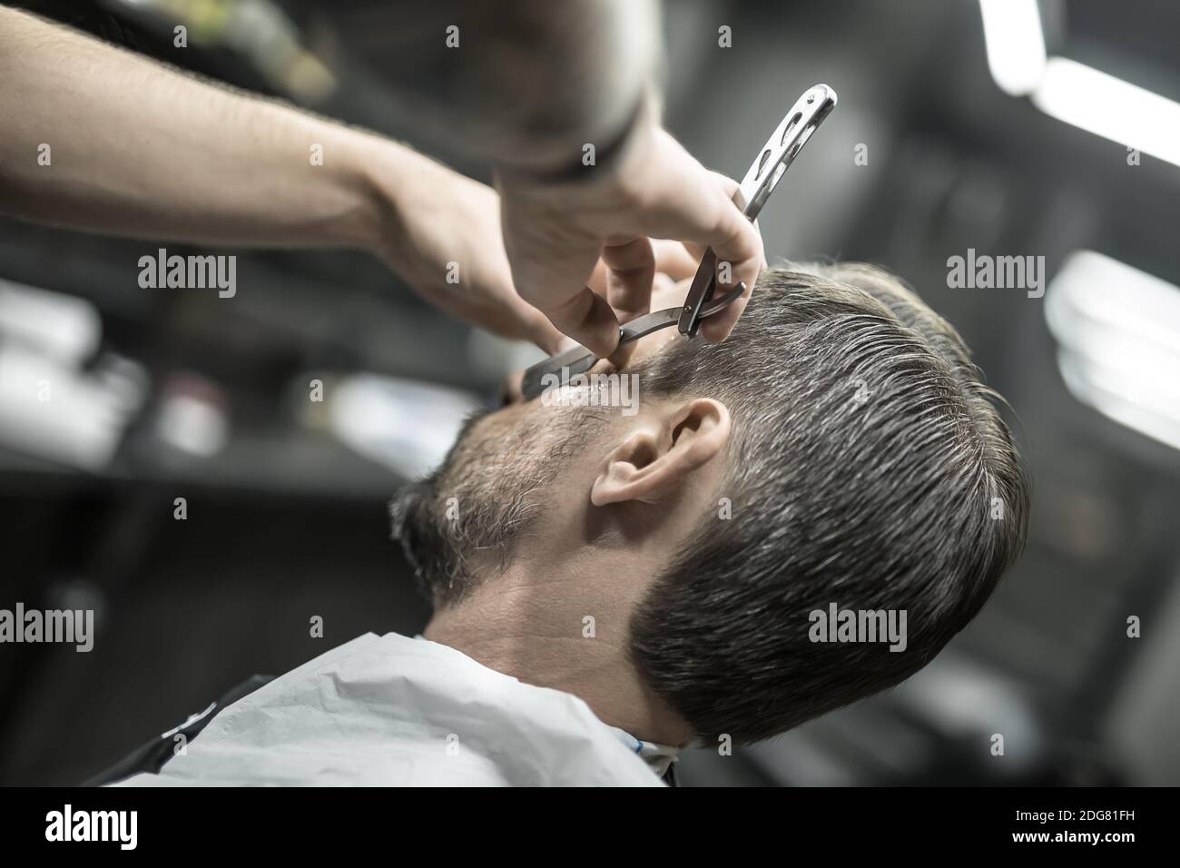 Trimming beard in barbershop Stock Photo - Alamy