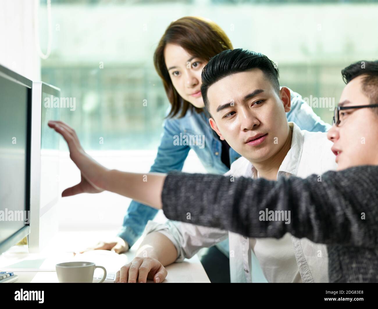 team of young asian people discussing business in office using desktop ...