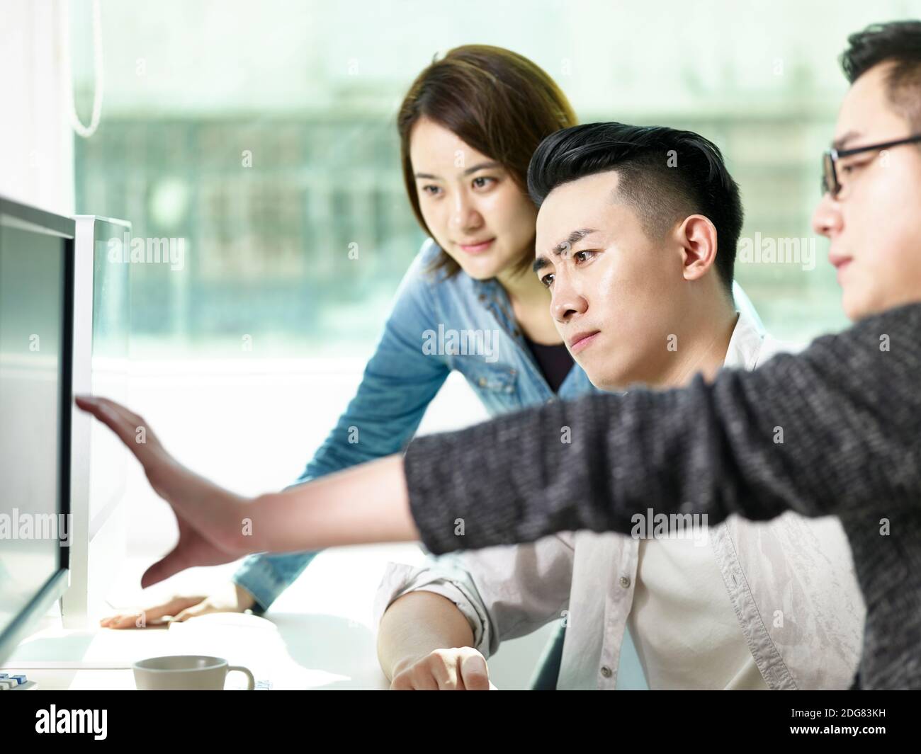 team of young asian people discussing business in office using desktop ...