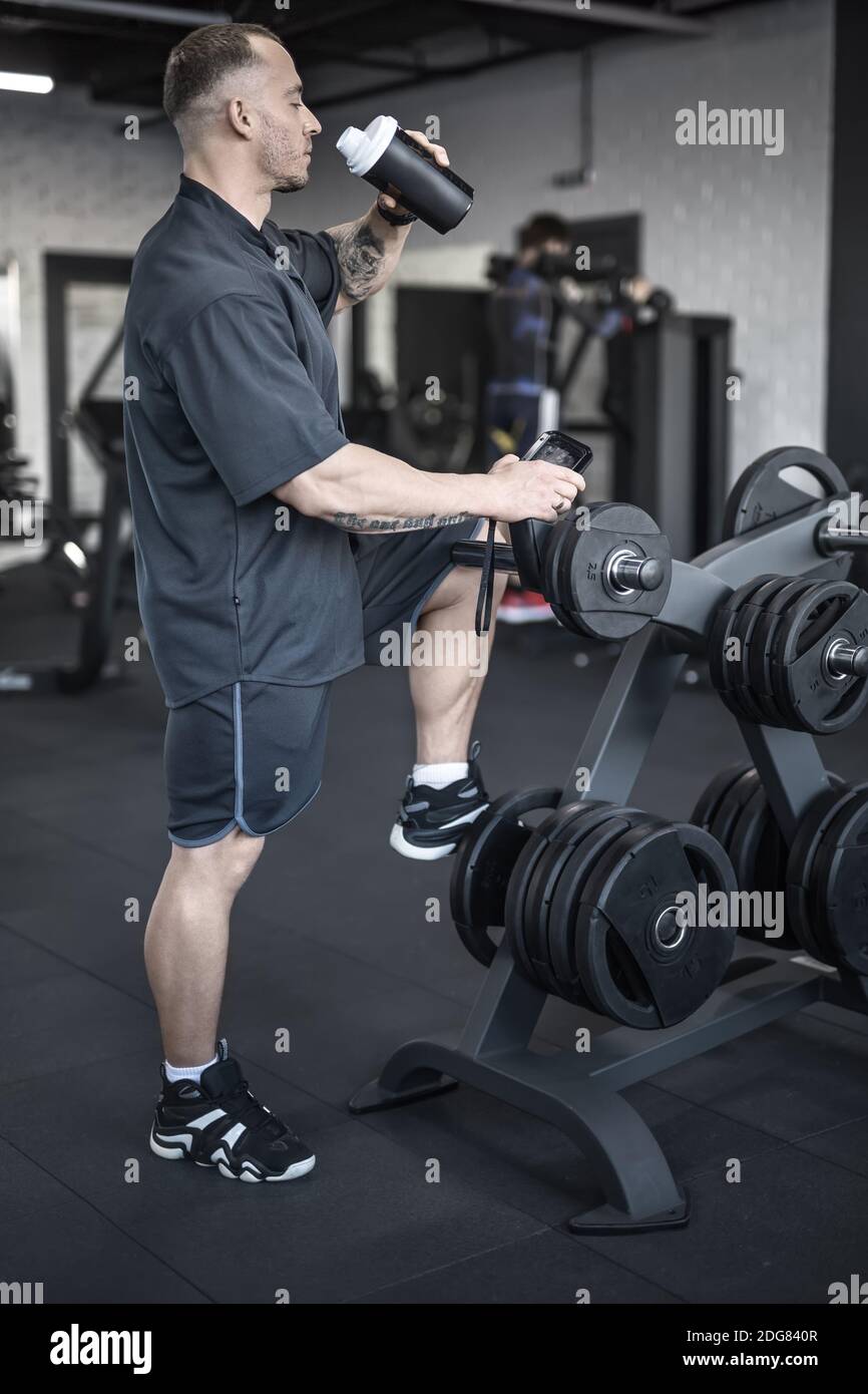 Muscular man has pause in gym Stock Photo - Alamy