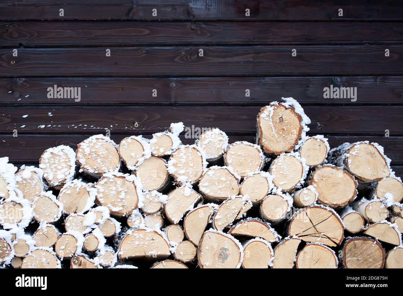 Pile of wood logs stored for winter covered with snow Stock Photo - Alamy
