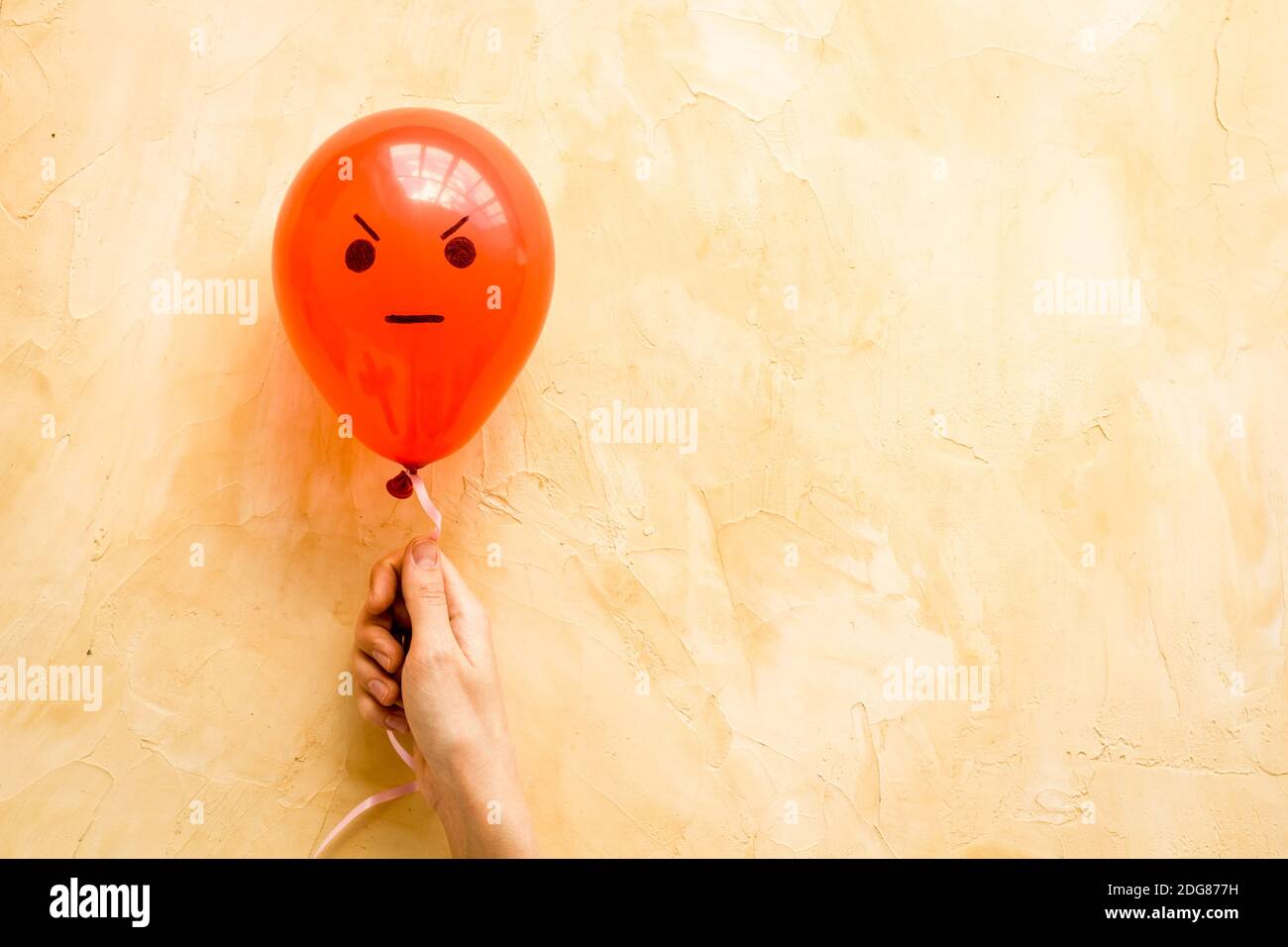 Anger emotion face on balloon - madness mood background. Top view, copy ...