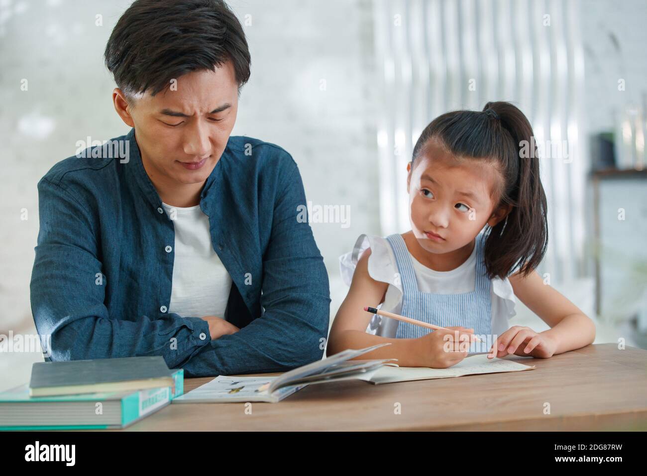 The young man to coaching daughter doing his homework Stock Photo - Alamy