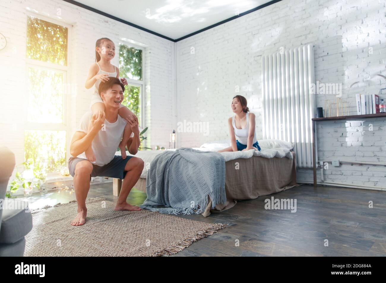 A family of three happy movement inside the bedroom Stock Photo - Alamy