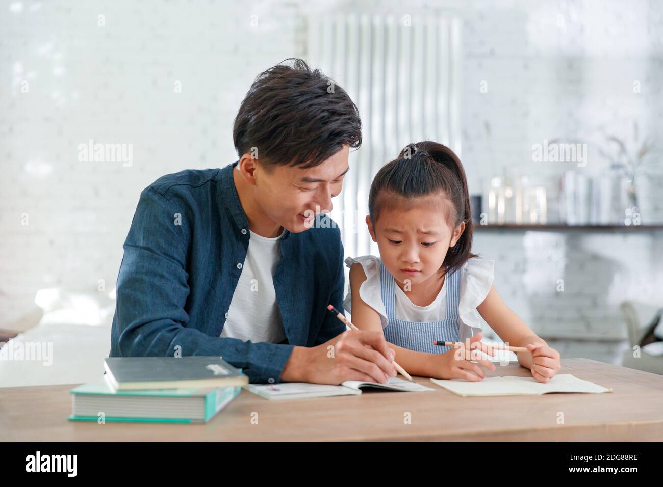 The young man to coaching daughter doing his homework Stock Photo - Alamy