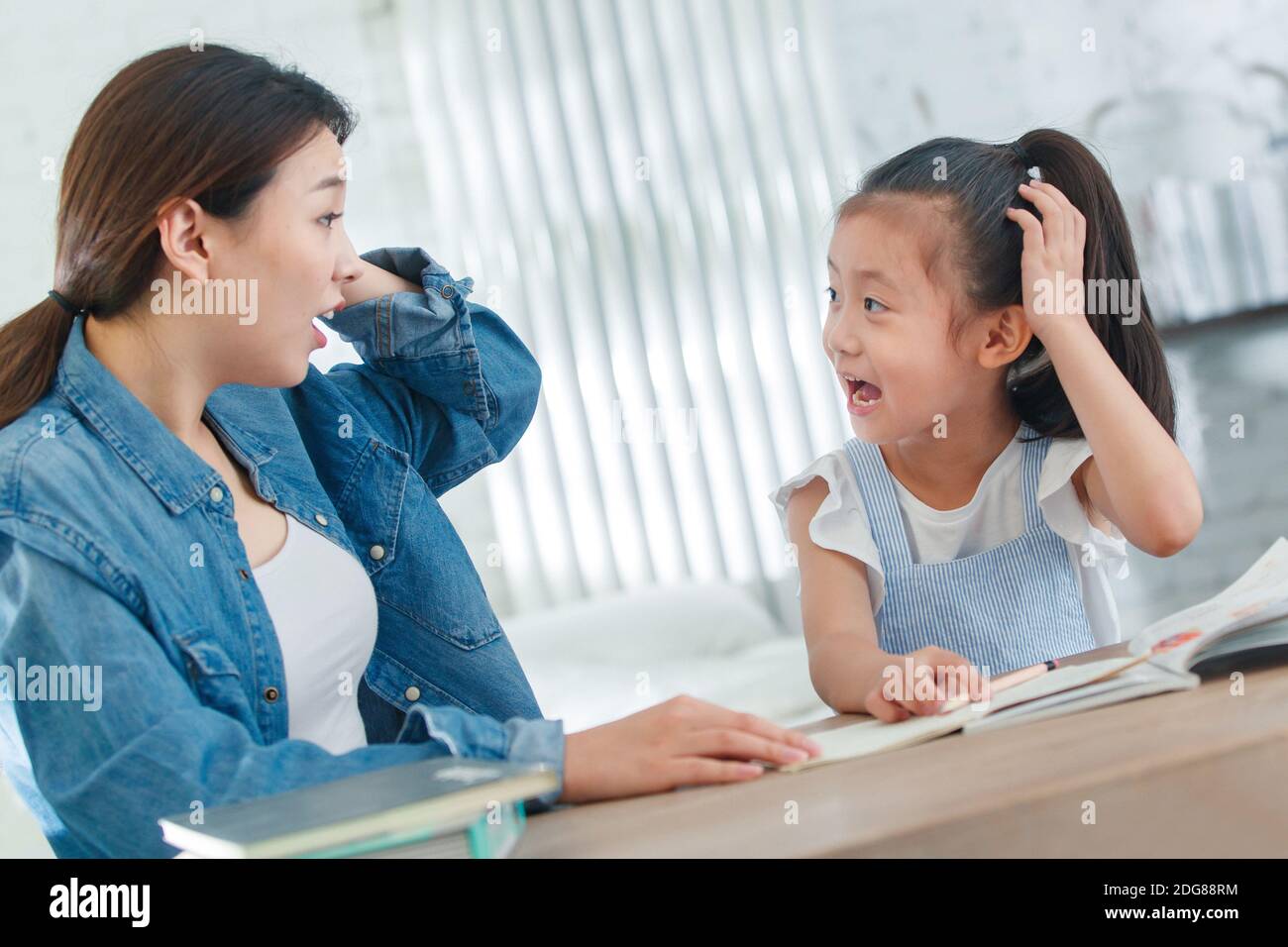 The young woman to coaching daughter doing his homework Stock Photo - Alamy