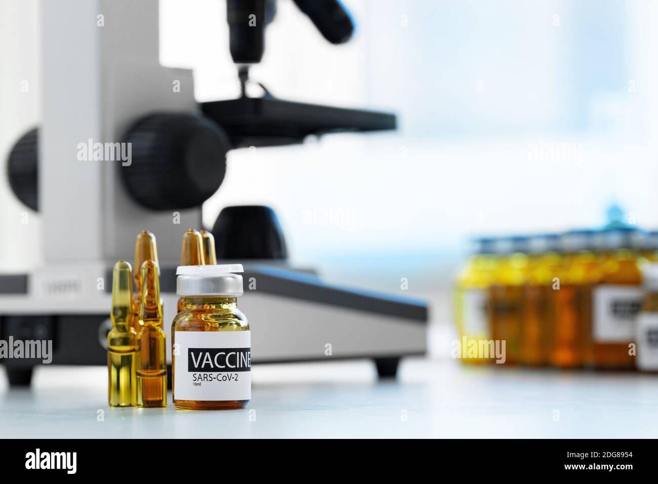 Vaccine in vial for injection on table against background of laboratory ...