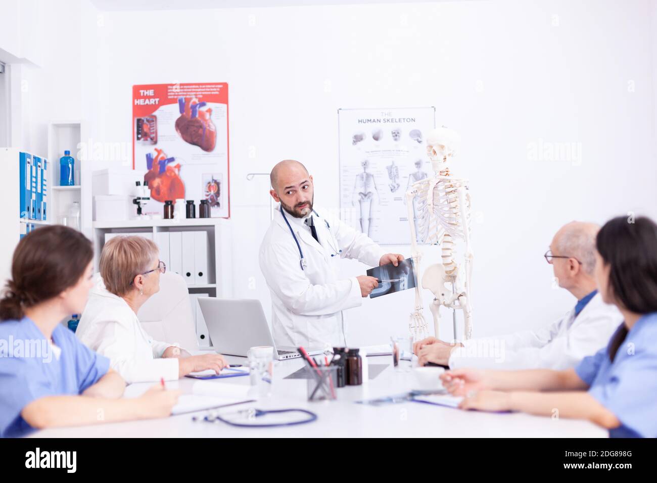 Surgeon holding radiography and making presentation in front of ...
