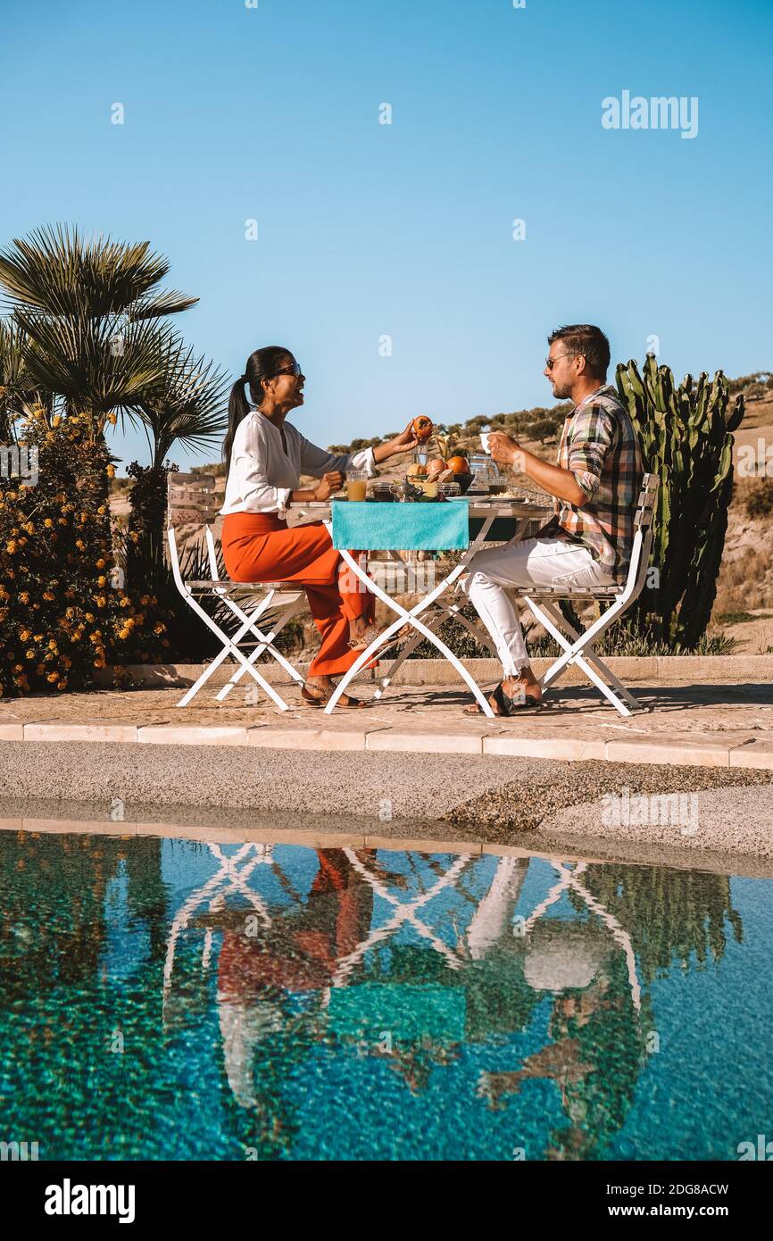 couple having breakfast in the garden looking out over the hills of ...