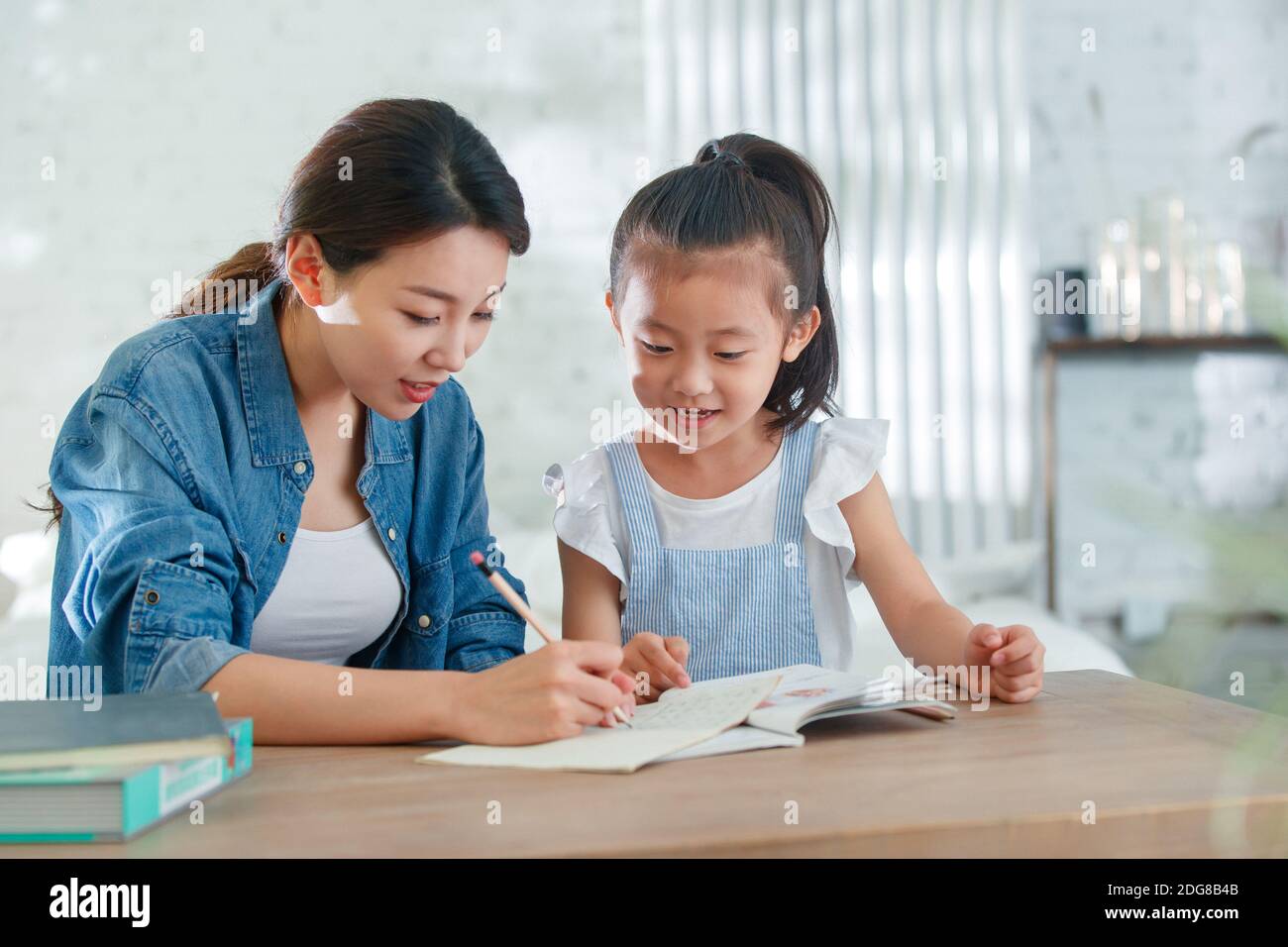 The young woman to coaching daughter doing his homework Stock Photo - Alamy