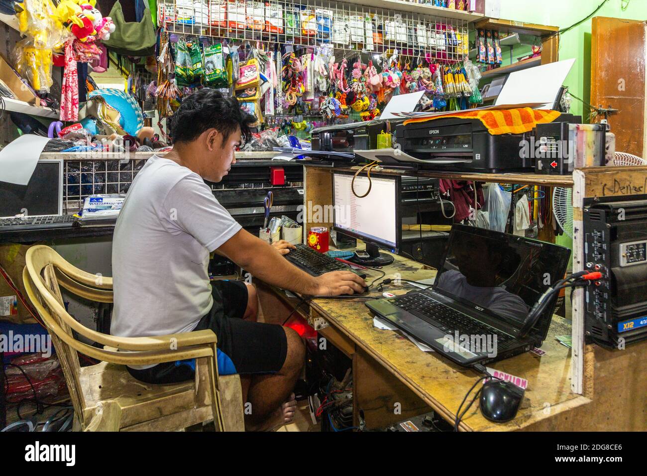 A Filipino small business owner working at his computer shop in Batangas, Philippines Stock ...