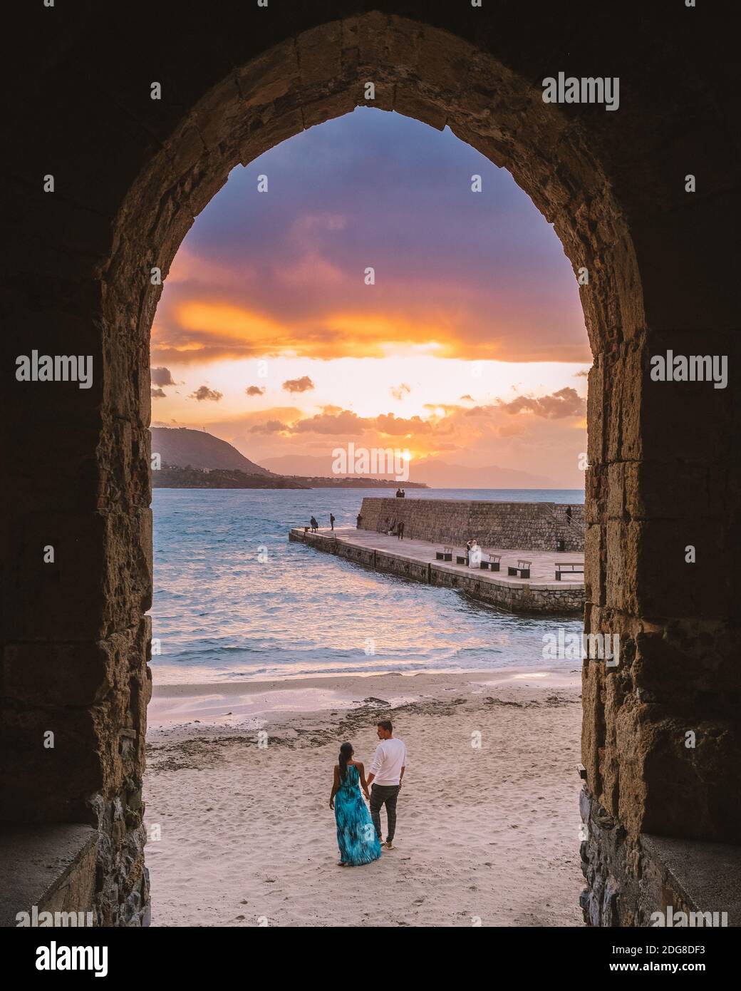 Cefalu Sicily, a couple watching the sunset at the beach of Cefalu ...