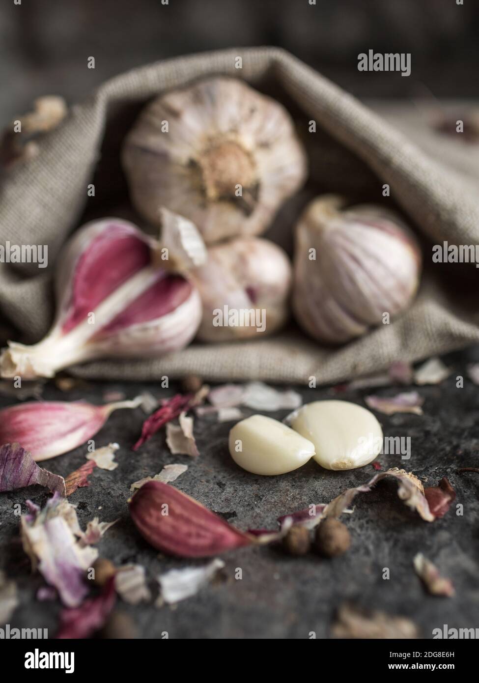 The process of cleaning garlic. Garlic and leaves on wooden background ...