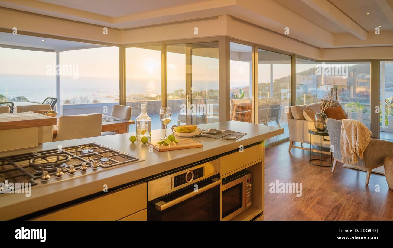 Sunny luxury home showcase interior kitchen with sunset ocean view ...