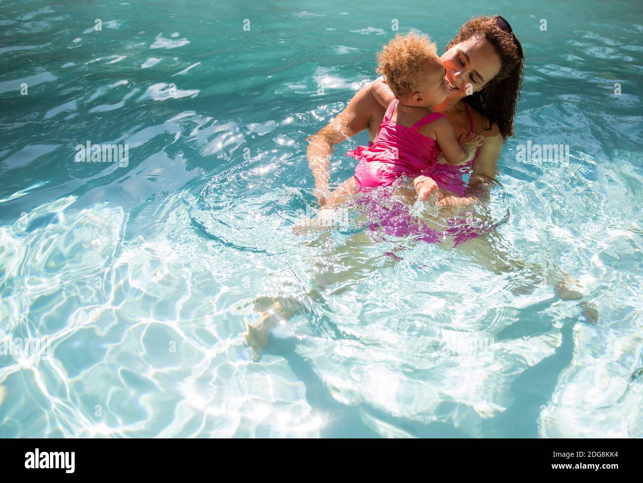 Happy Mother And Daughter Swimming In Sunny Summer Swimming Pool Stock