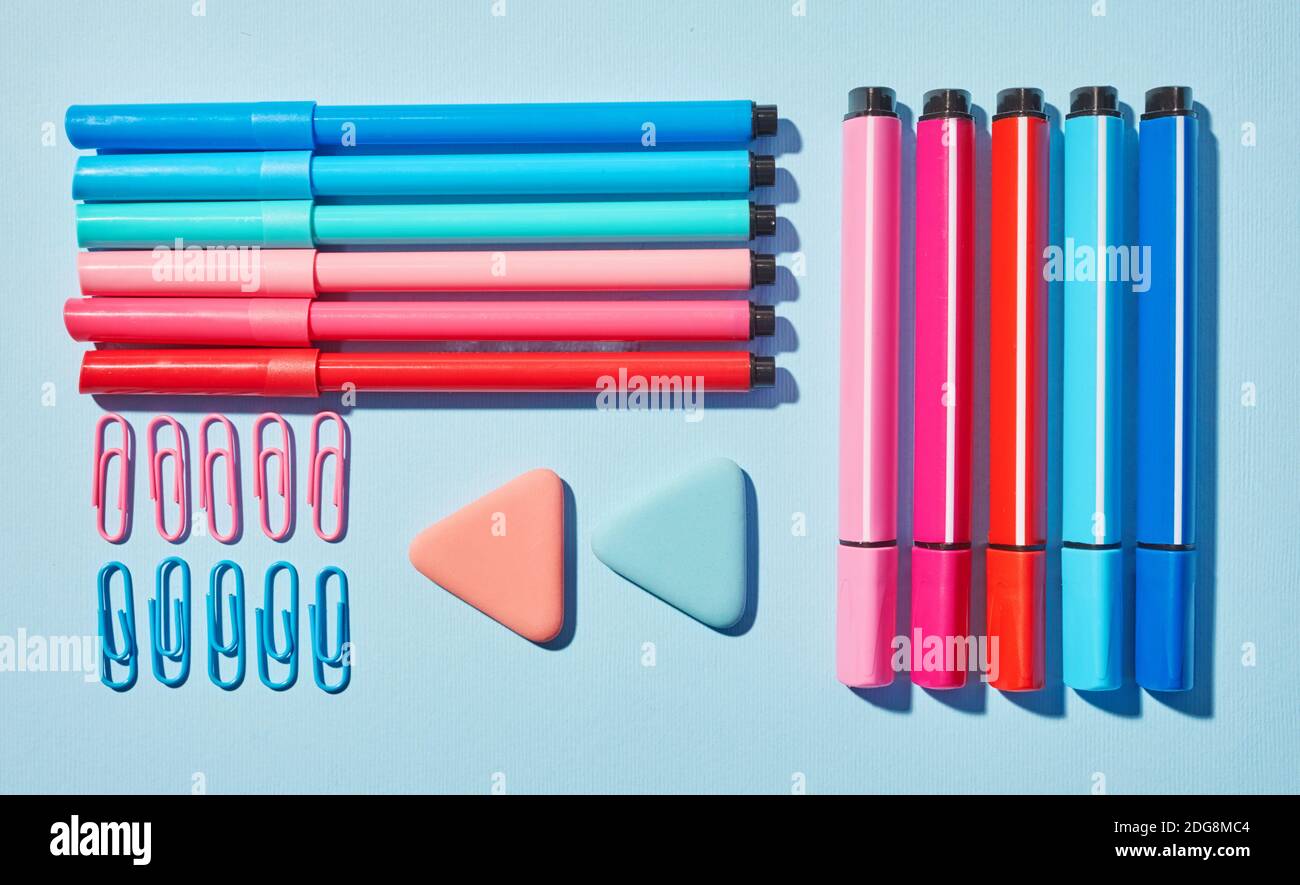 Bright markers and eraser on a blue background. School objects for ...