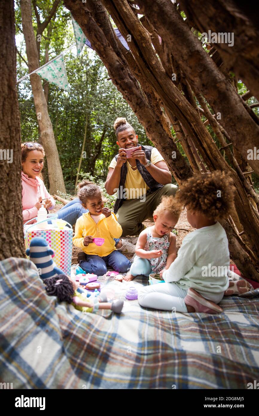 Family playing tea party in tree fort Stock Photo - Alamy