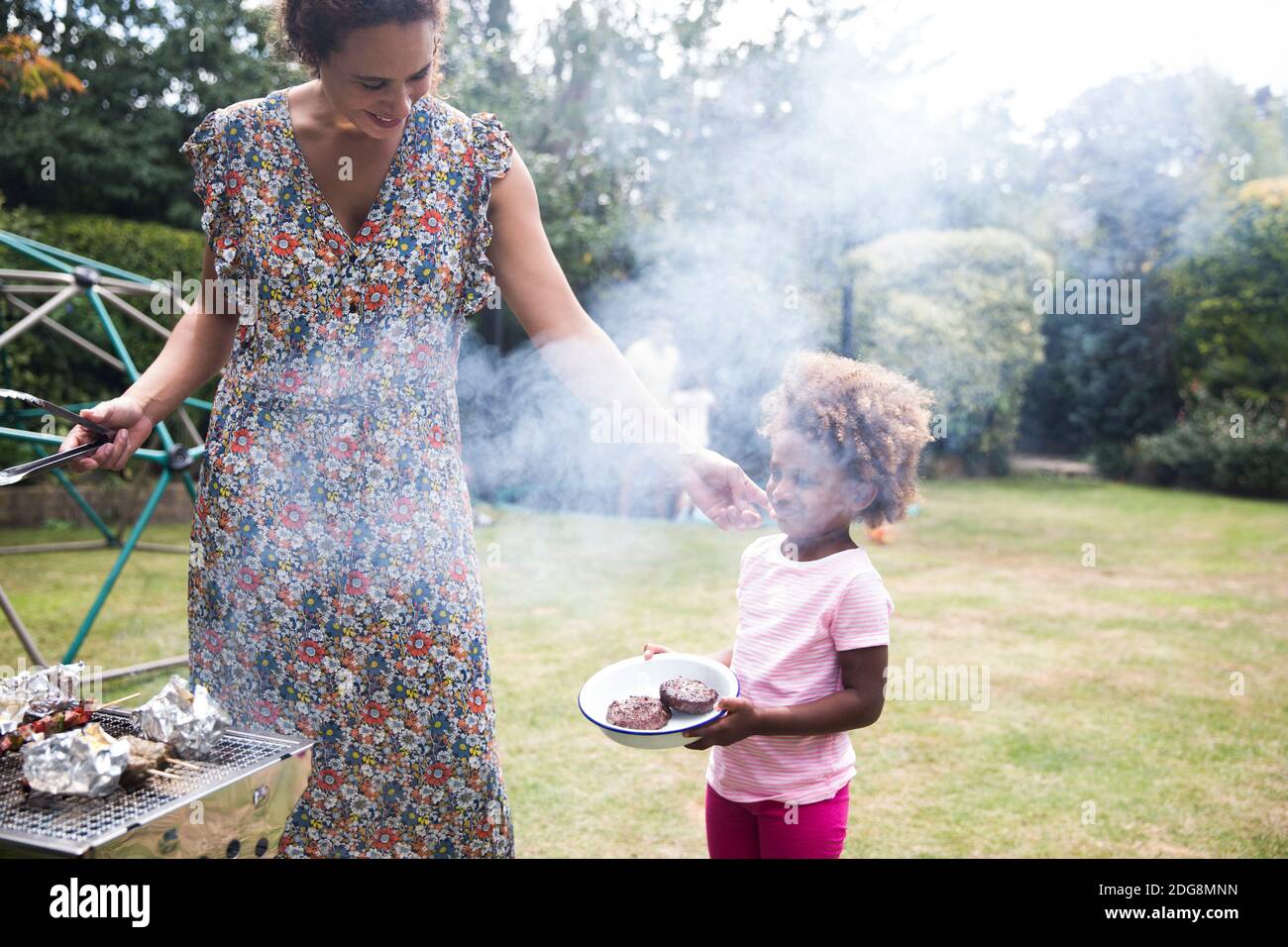 Mother and daughter barbecuing in summer backyard Stock Photo - Alamy