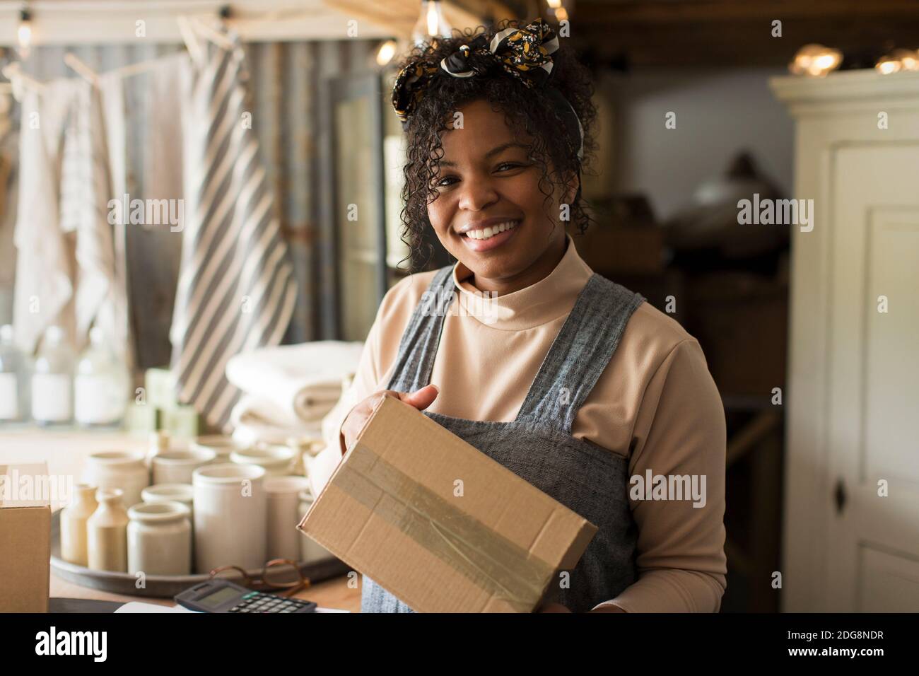 Portrait happy female shop owner with package Stock Photo - Alamy