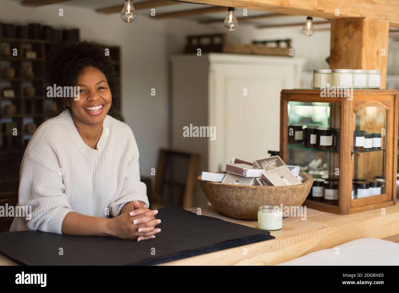 Portrait happy friendly female shop owner at counter Stock Photo - Alamy
