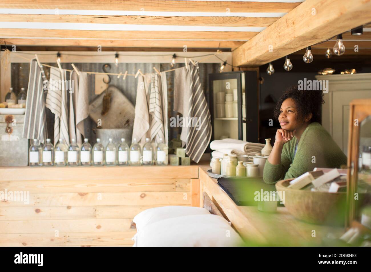Thoughtful female shop owner behind shop counter Stock Photo - Alamy