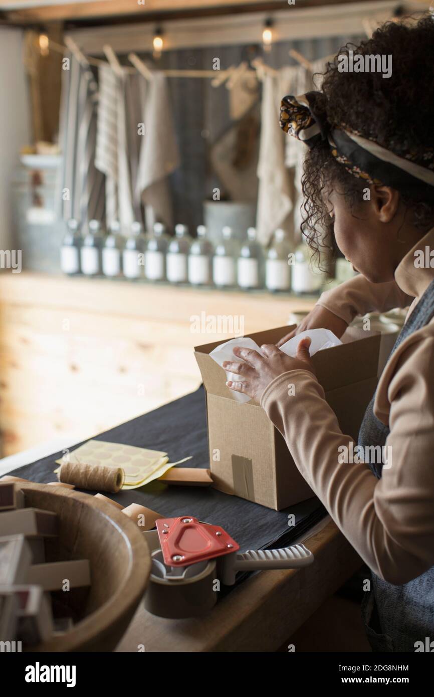 Female shop owner preparing package for shipping Stock Photo - Alamy