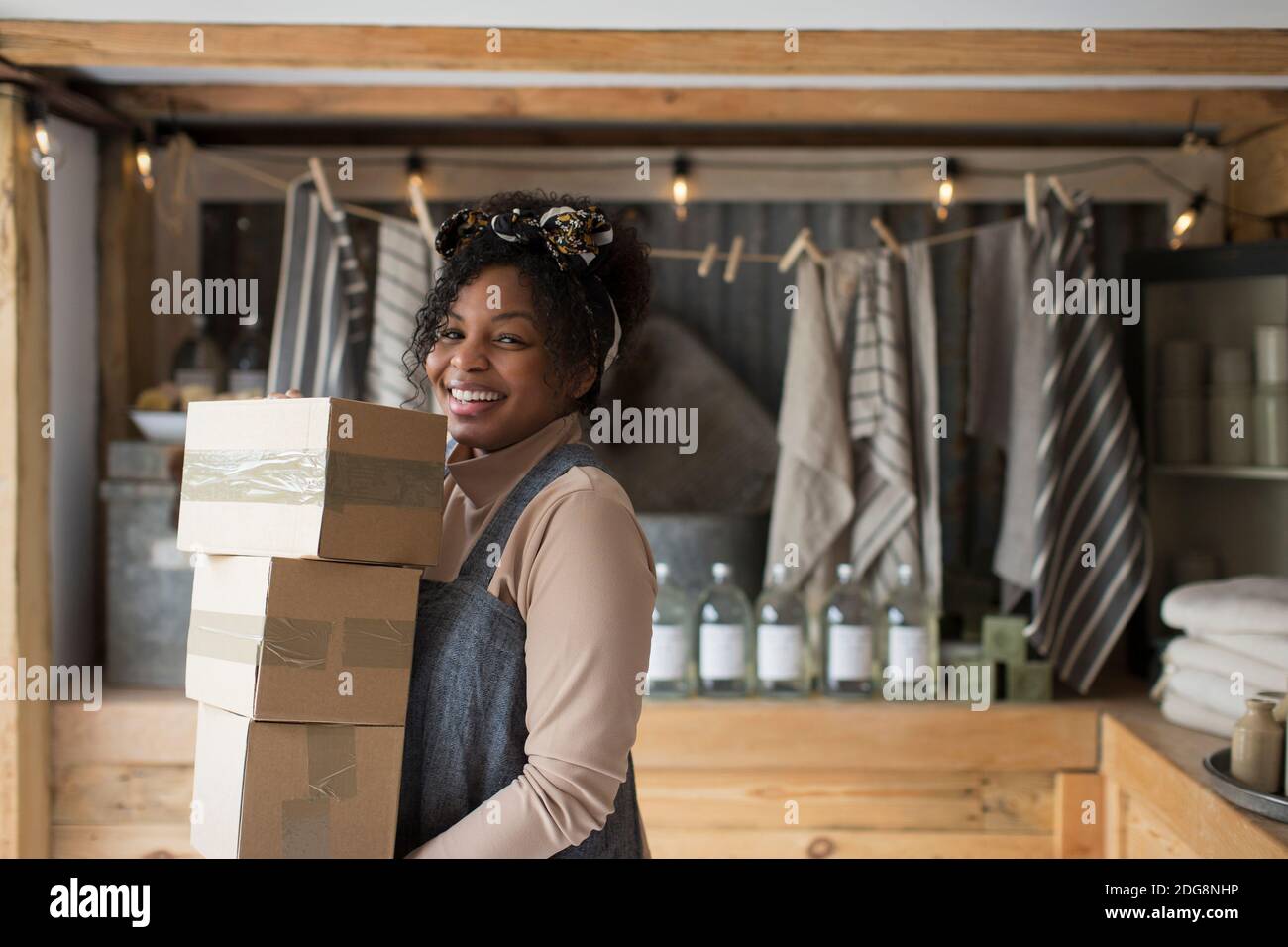 Portrait confident female shop owner carrying boxes in shop Stock Photo ...