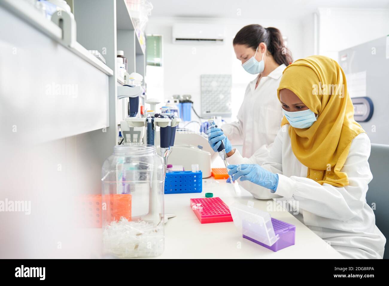 Female scientists in face masks and hijab working in laboratory Stock ...