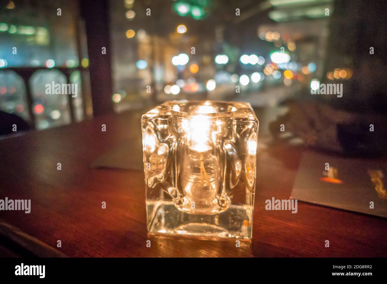 Candle at night with city street lights in the background Stock Photo ...