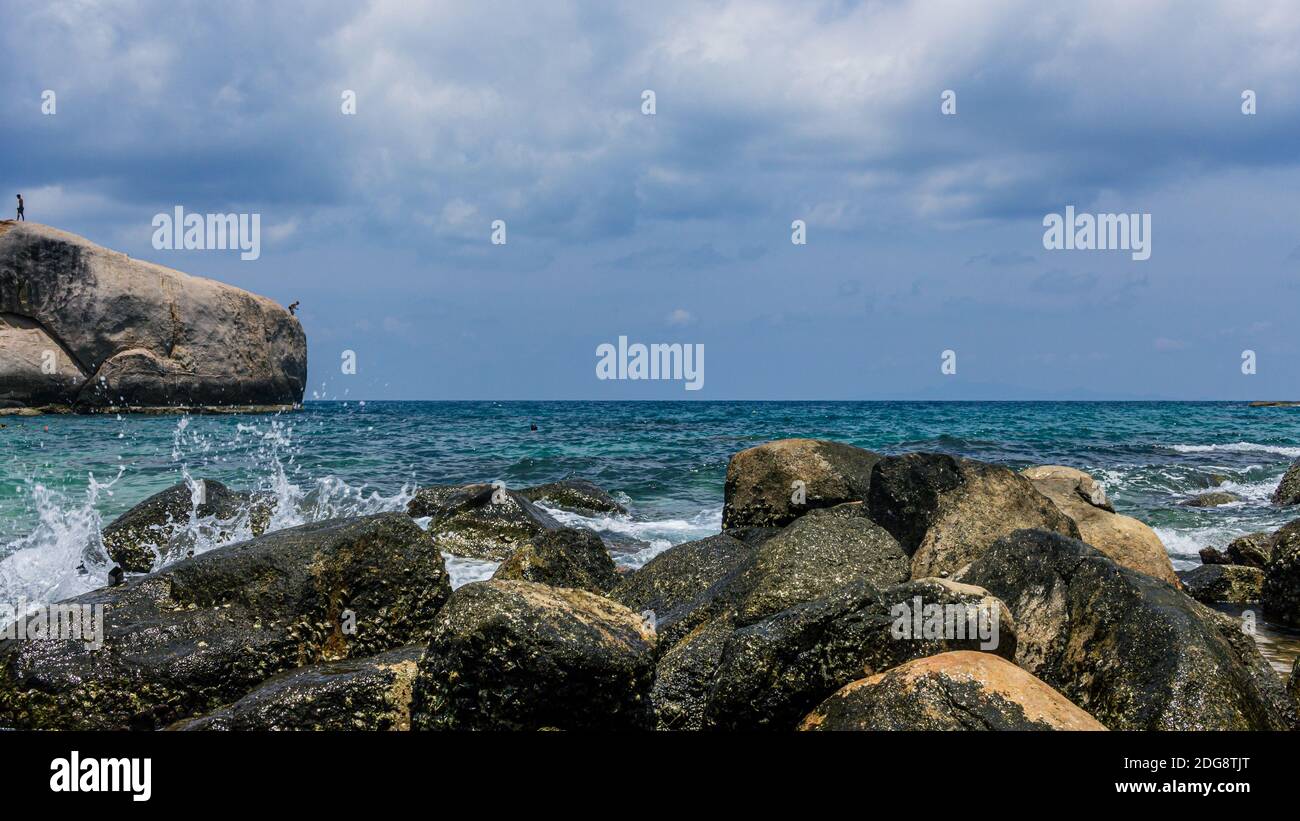 Huge jumping rock in crystal blue clear sea water, rocky island beach ...
